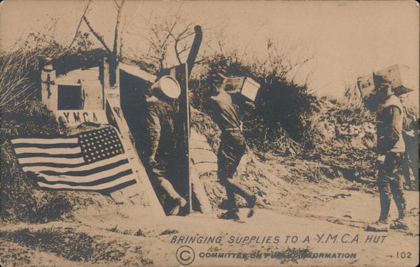 Bringing supplies to a Y.M.C.A. hut. Men in uniform carrying boxes ...